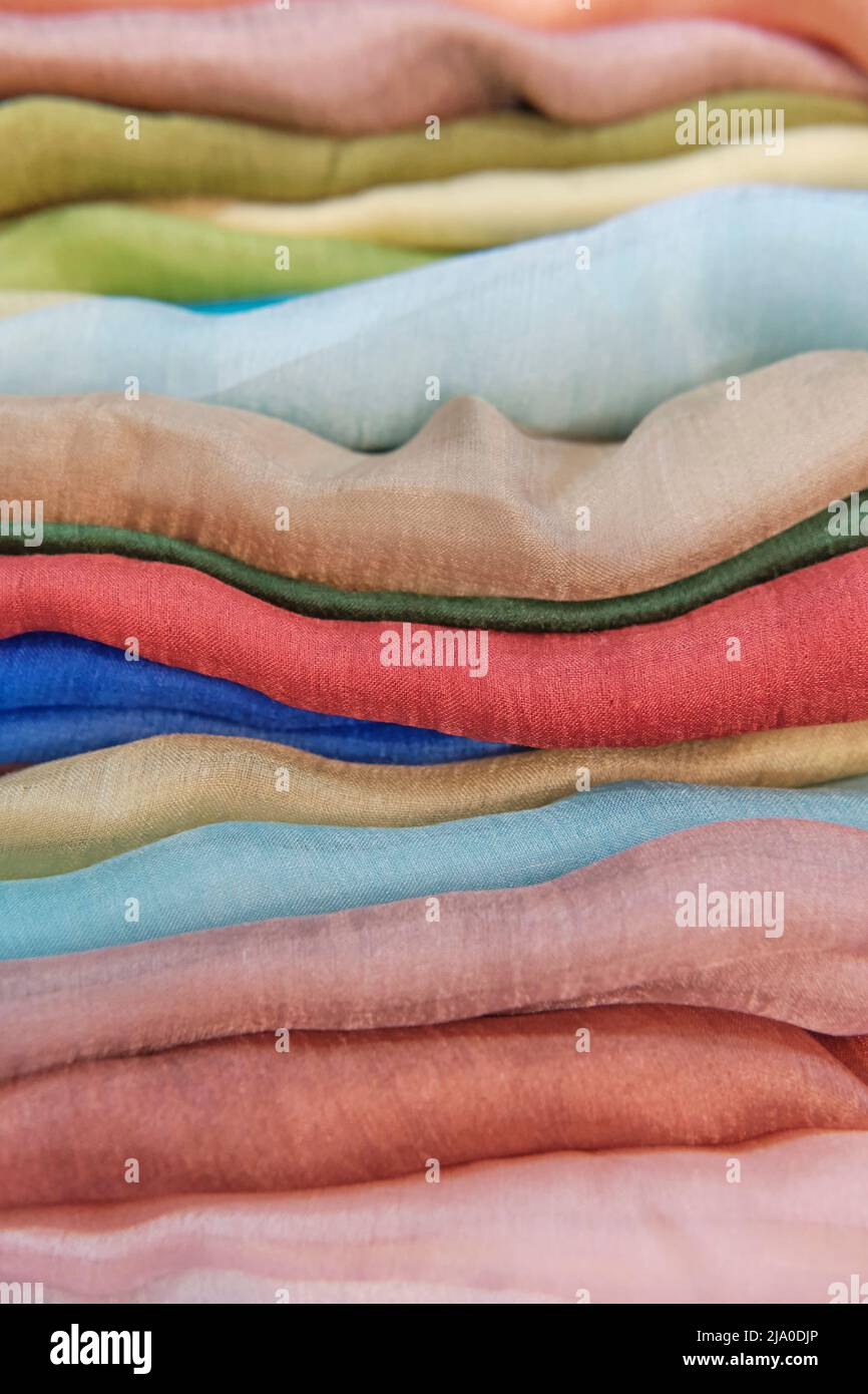 Multi-colored monochromatic silk soft fabrics stacked horizontally ...