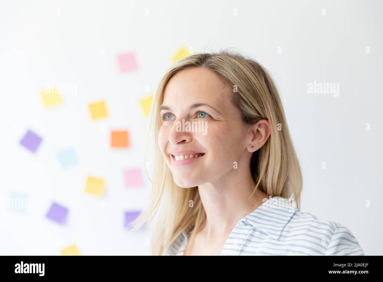 Portrait of pretty young blonde woman with beautiful laugh stands in ...