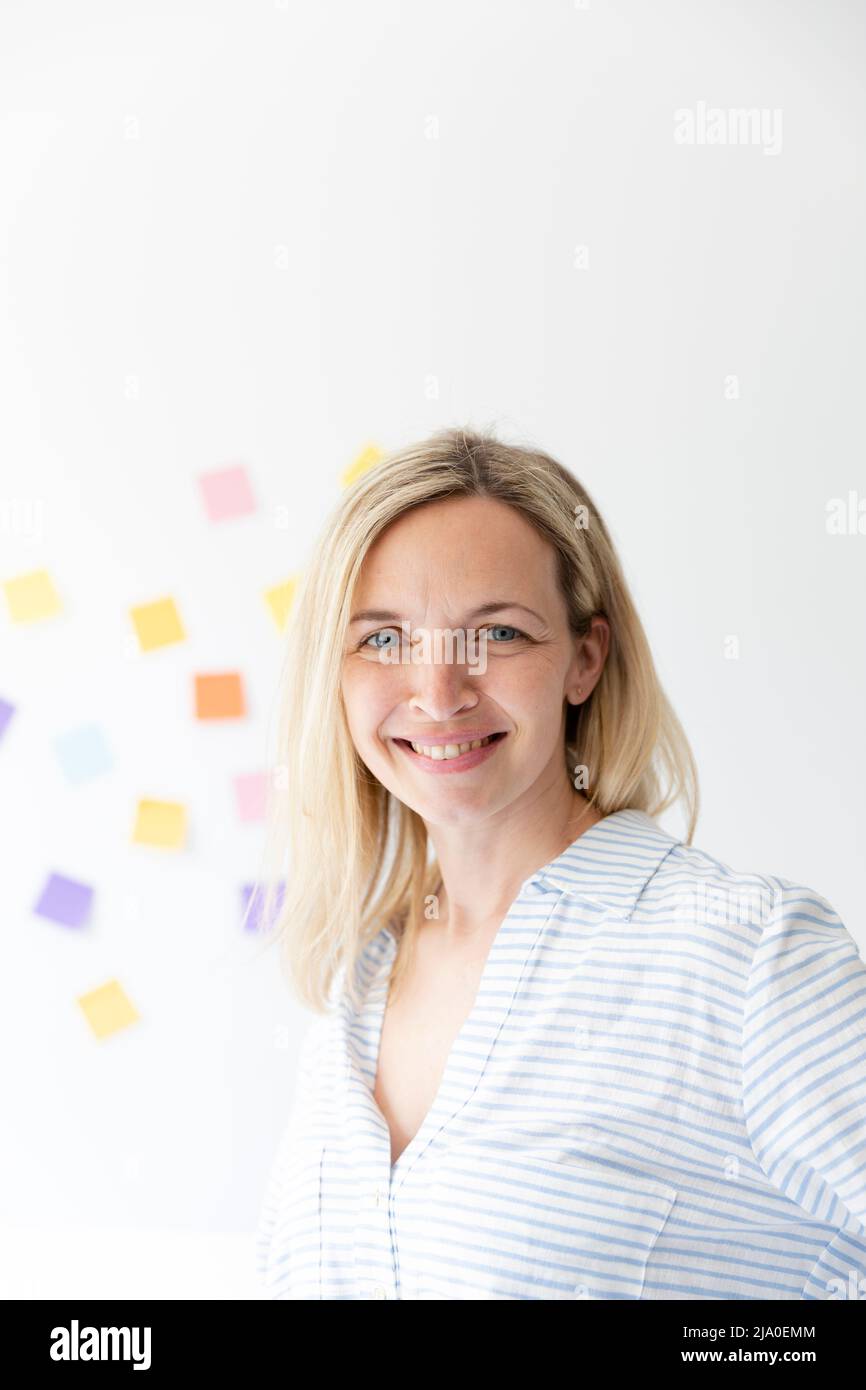 Portrait of pretty young blonde woman with beautiful laugh stands in ...