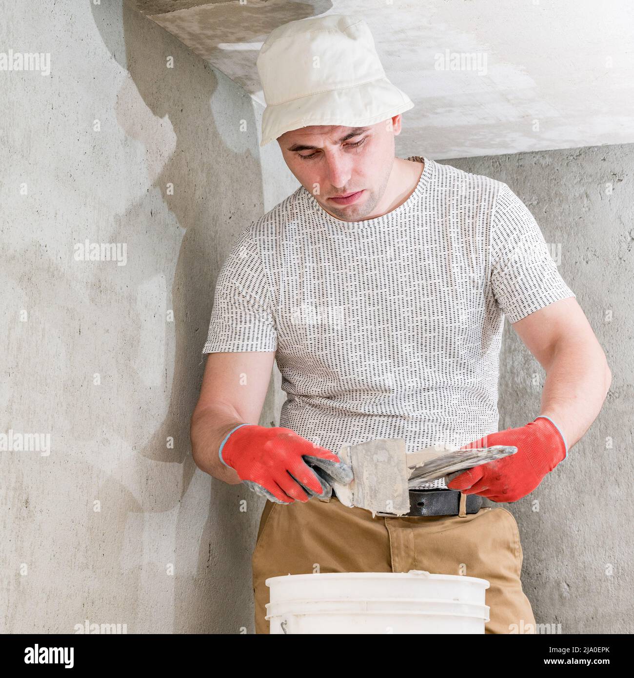 The master works with lime plaster, leveling the wall with a spatula ...