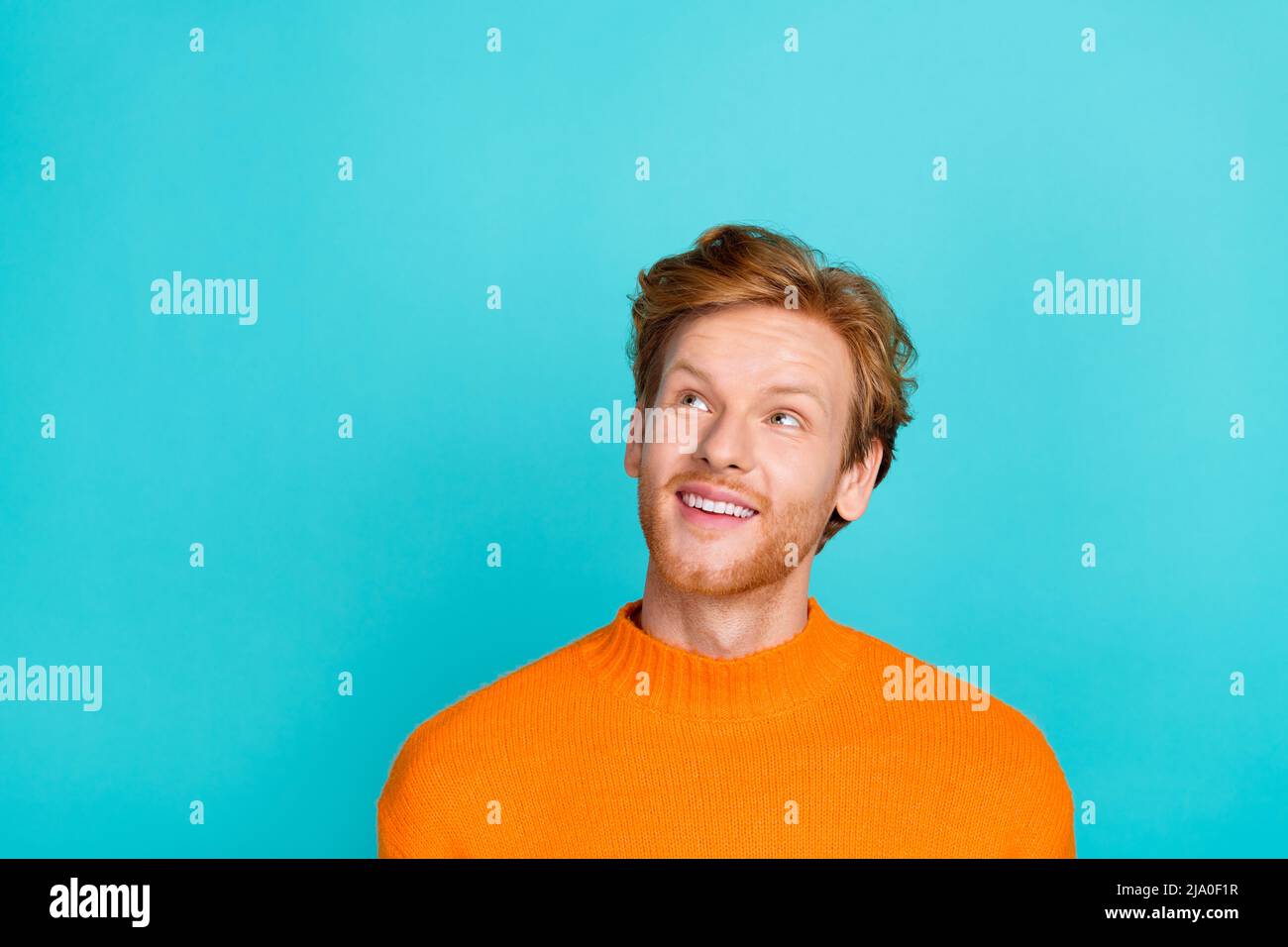 Photo of funny dreamy guy dressed orange sweater smiling looking empty ...