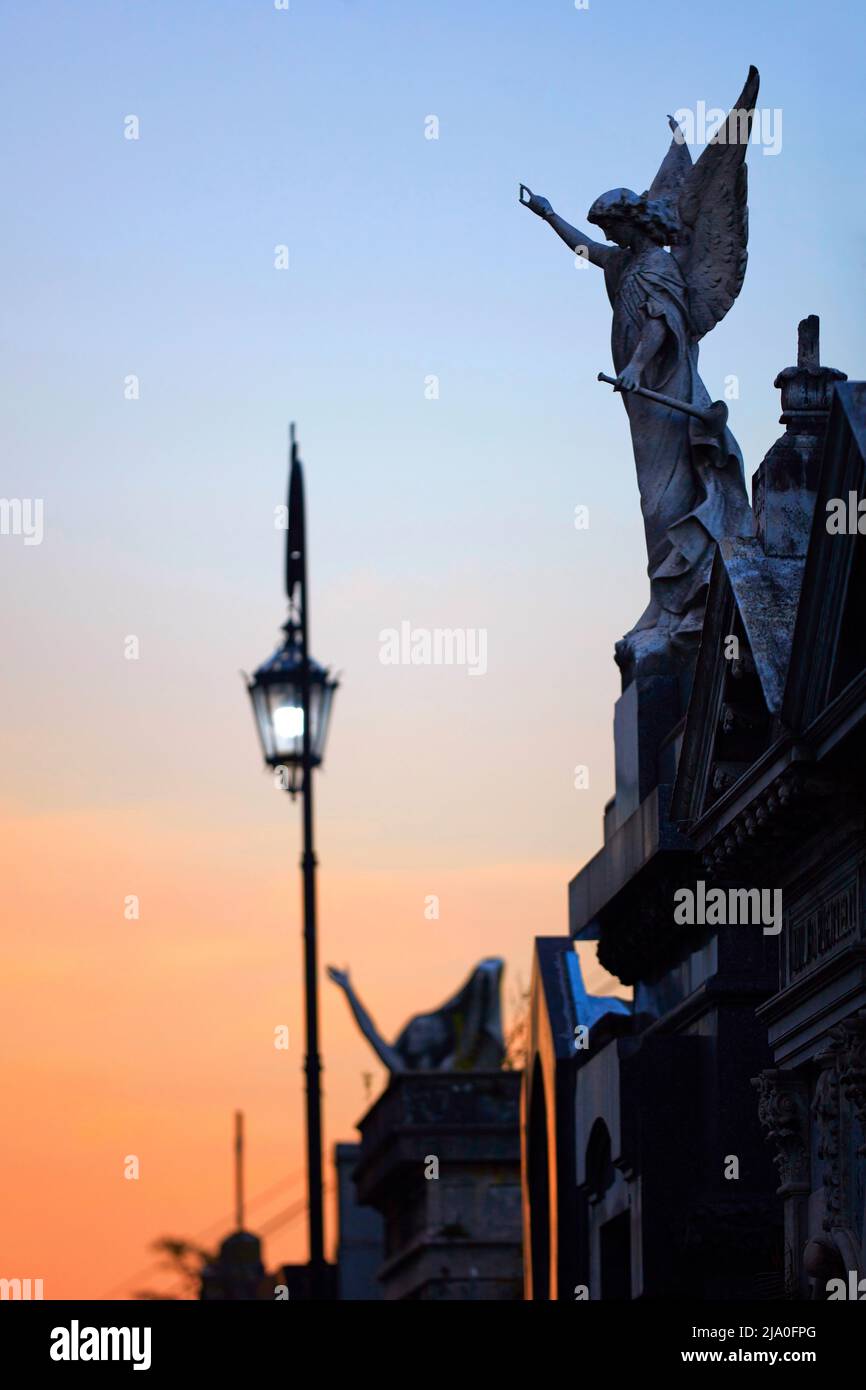 Statues of angels inside the Recoleta Monumental Cementery at dusk ...