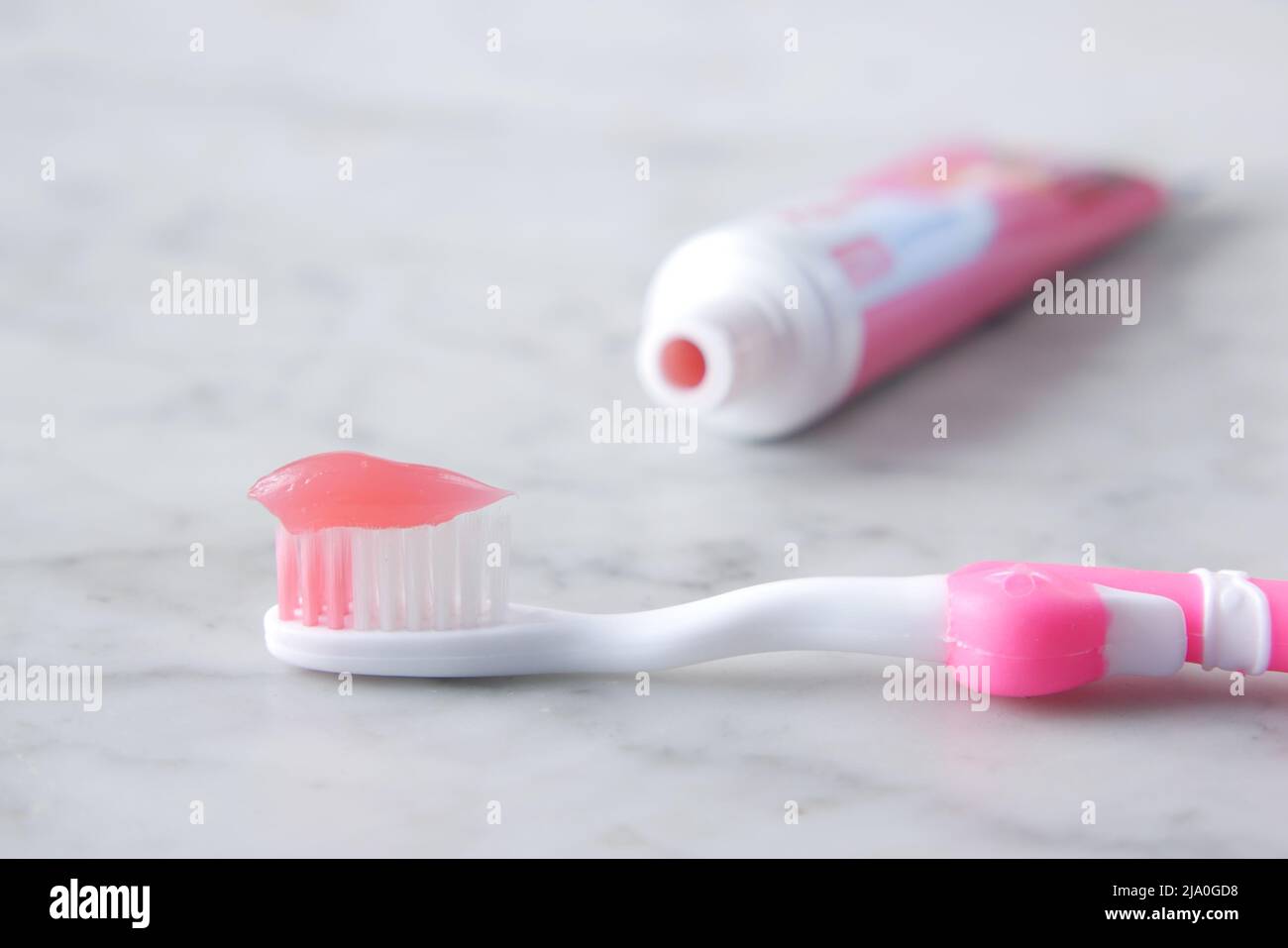 pink color child tooth brush with paste Stock Photo - Alamy