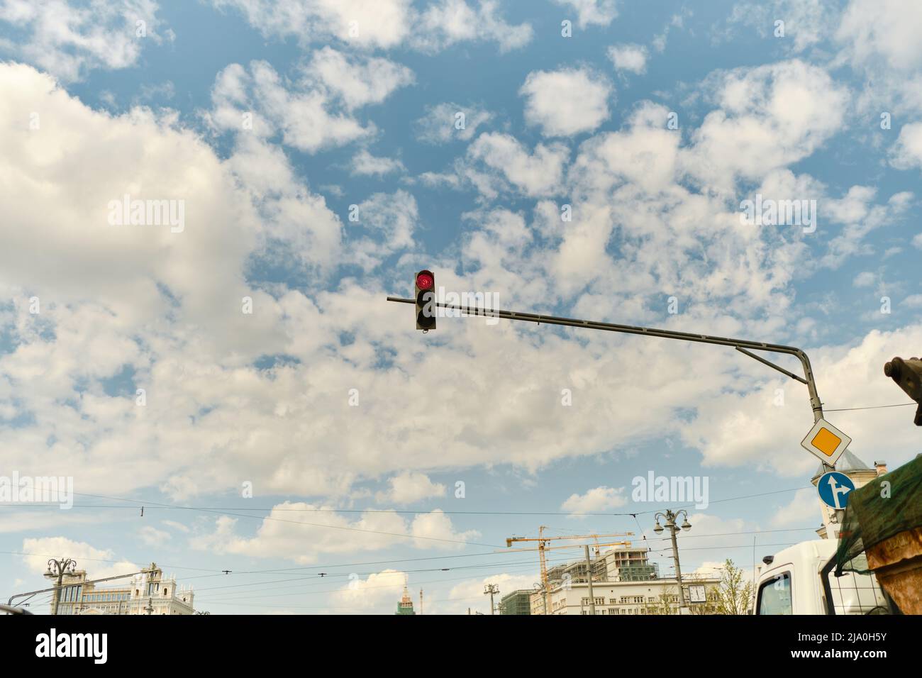 Low angle view of traffic light against blue sky with white clouds ...