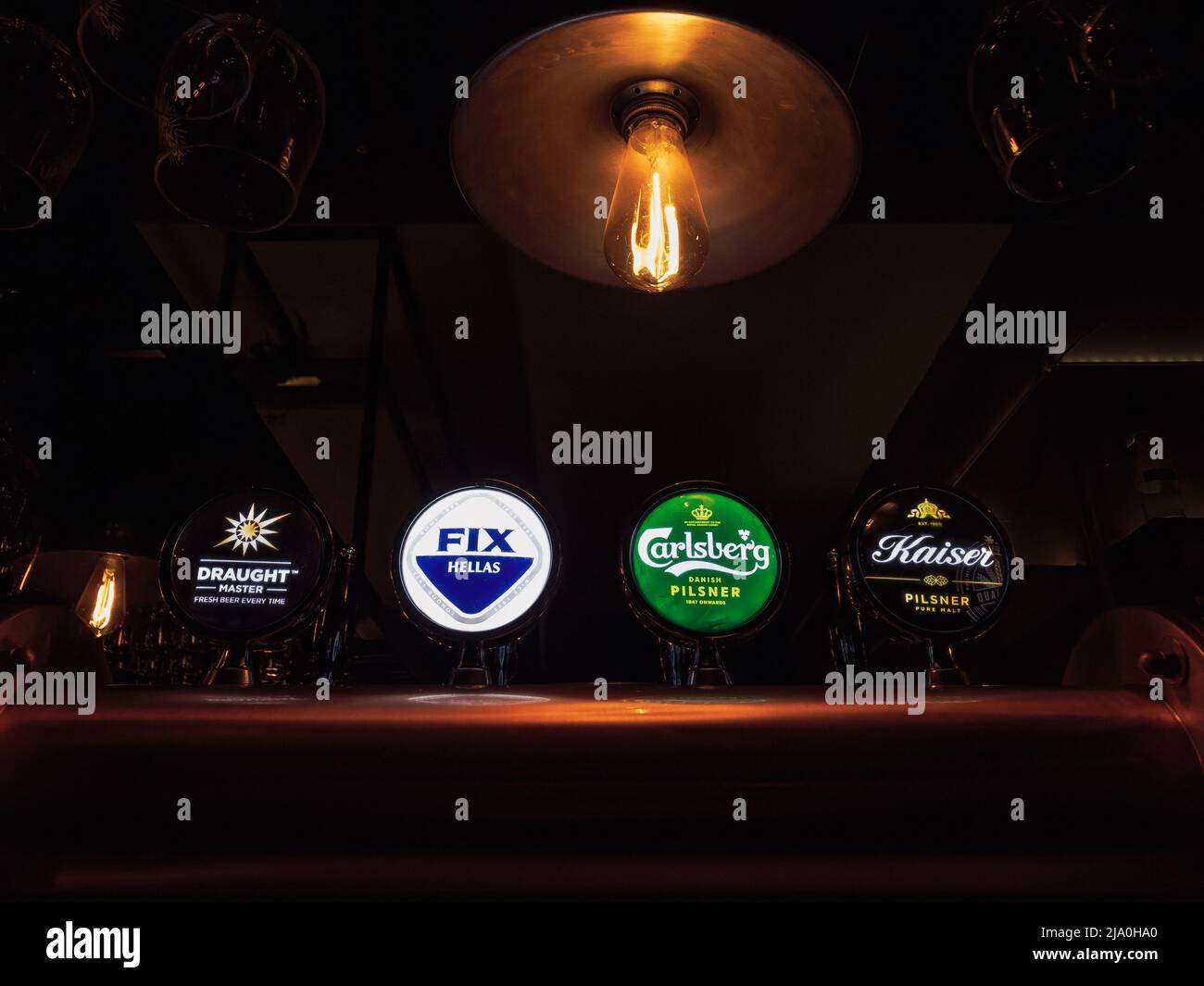 Bar beer taps with various names and illuminated logos of brands ...
