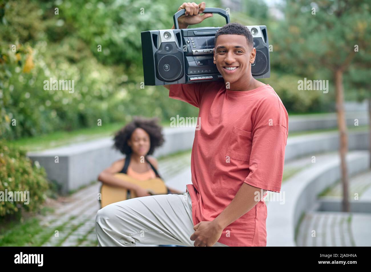 Guy with record-player on shoulder smiling aside Stock Photo - Alamy
