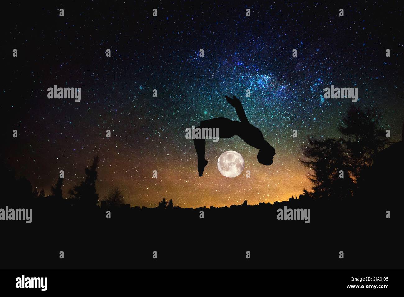 sporty man jumping against the night starry sky background. Mixed media ...