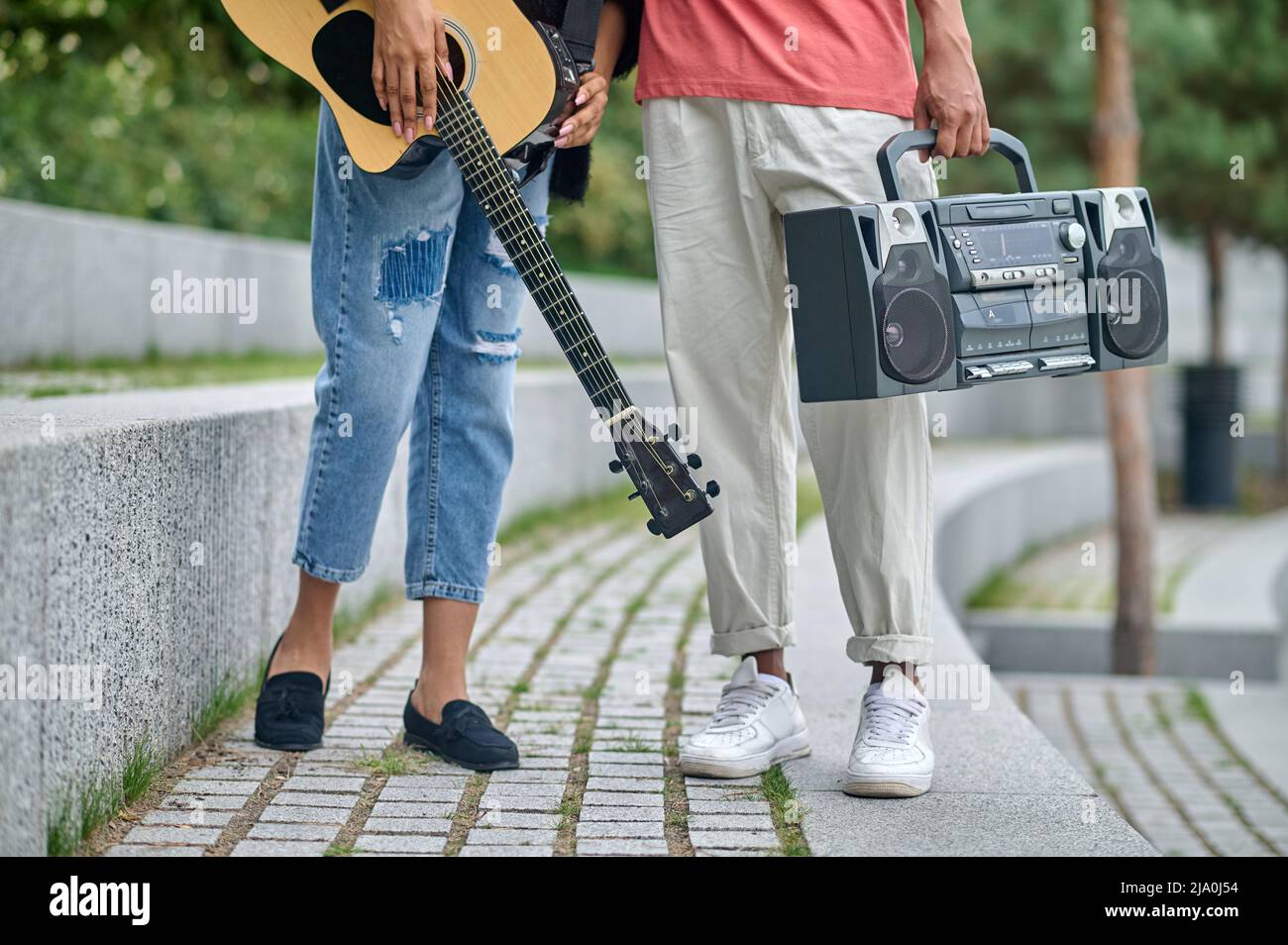 Guitar and record-player in hands of young people Stock Photo - Alamy
