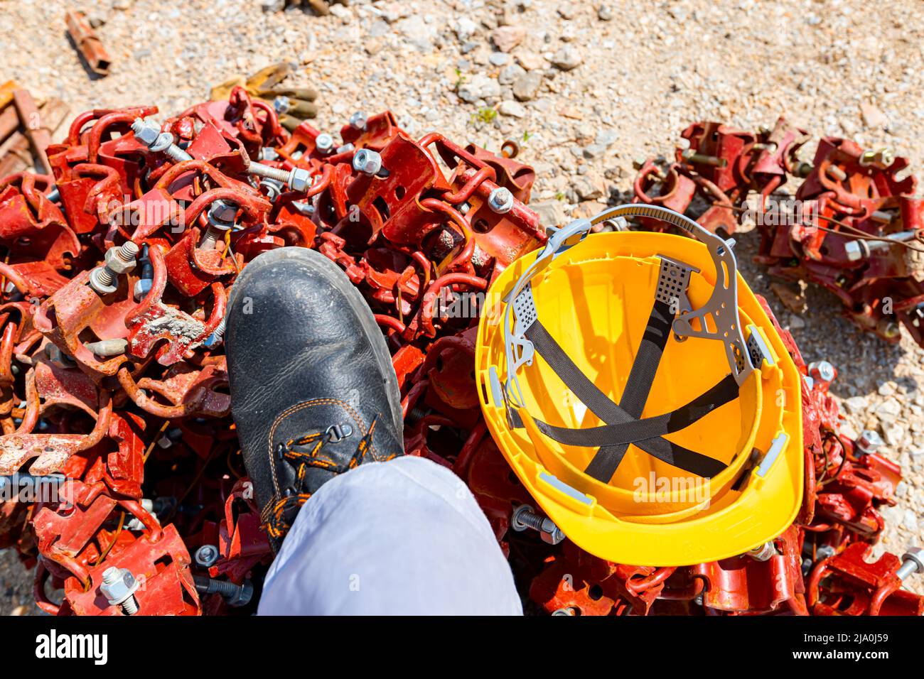 View from above on worker who wears safety shoe and tramples on pile ...