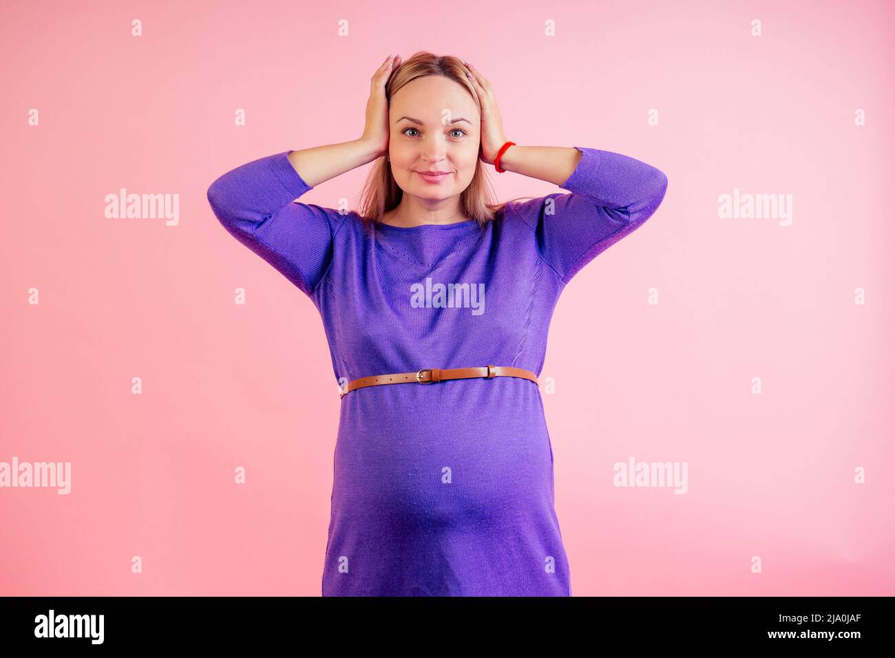 Beautiful blonde pregnant woman in a violet dress with big baby bump ...