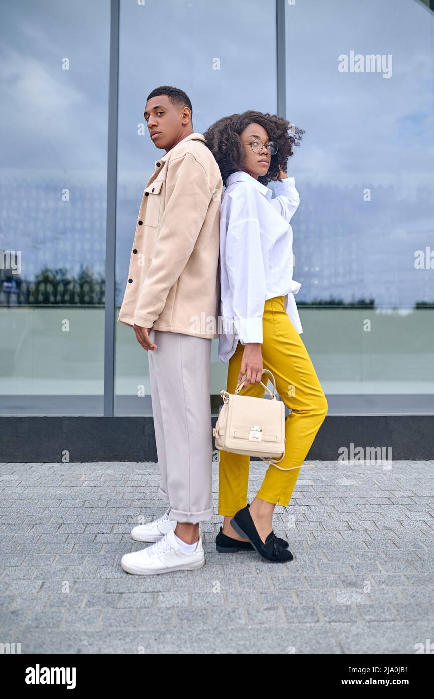 Guy and girl standing back to back Stock Photo - Alamy