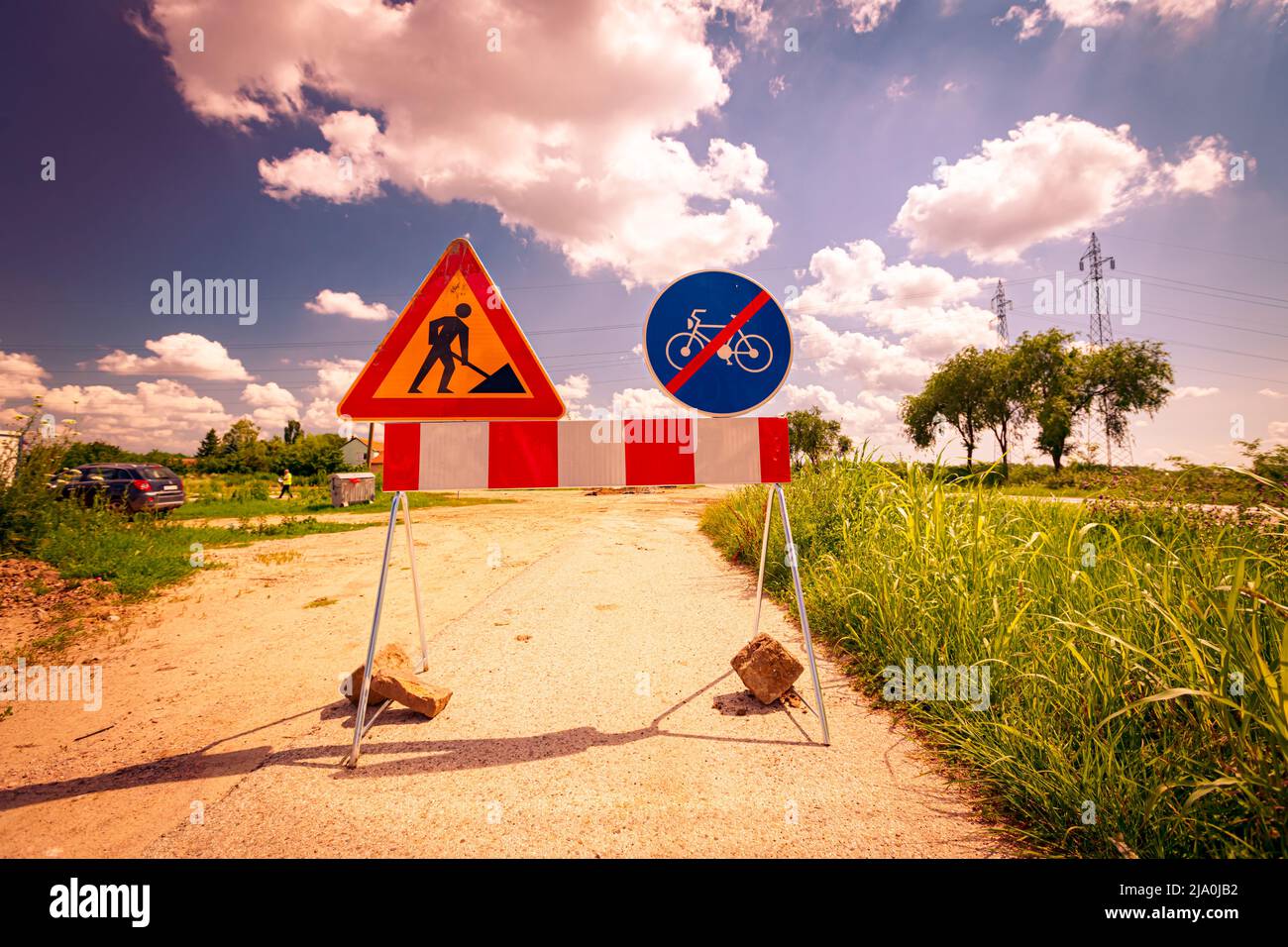 Two signs are set on the road at construction site, triangle sign, work ...