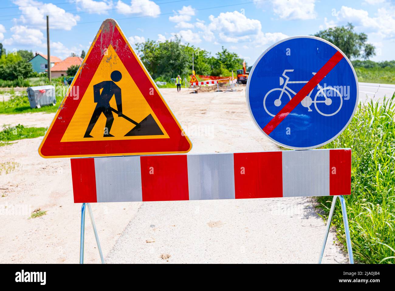 Two signs are set on the road at construction site, triangle sign, work ...