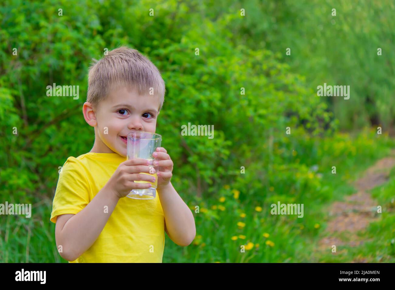 The boy drinks water from a glass. Pure water. Summer. selective focus Stock Photo - Alamy