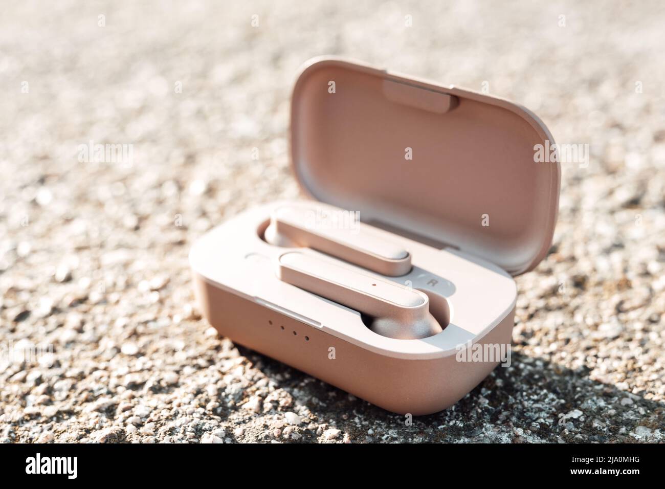 True wireless earbuds in case on natural stone background Stock Photo ...