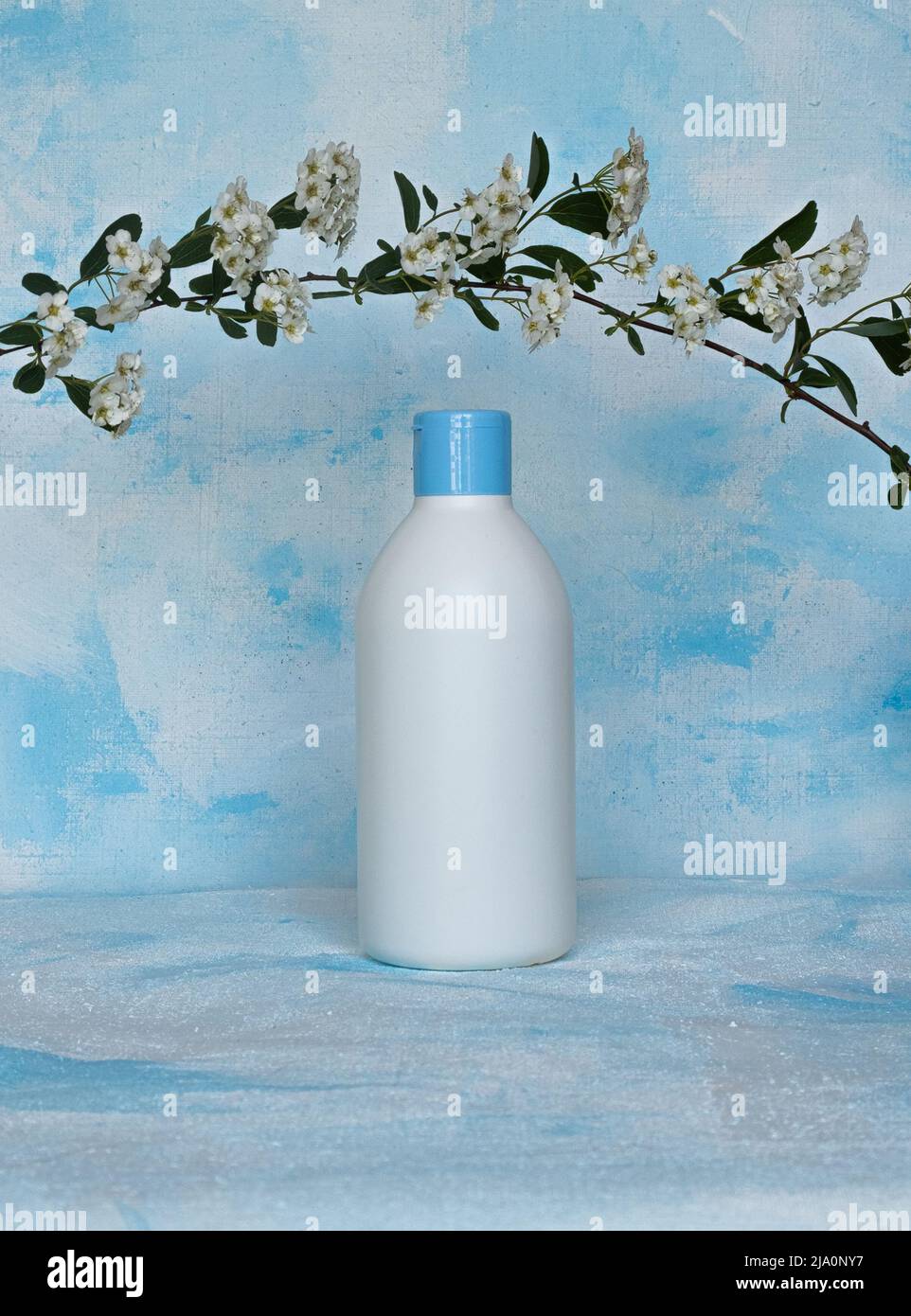 Bottle for cosmetic products without a label with a flower branch ...