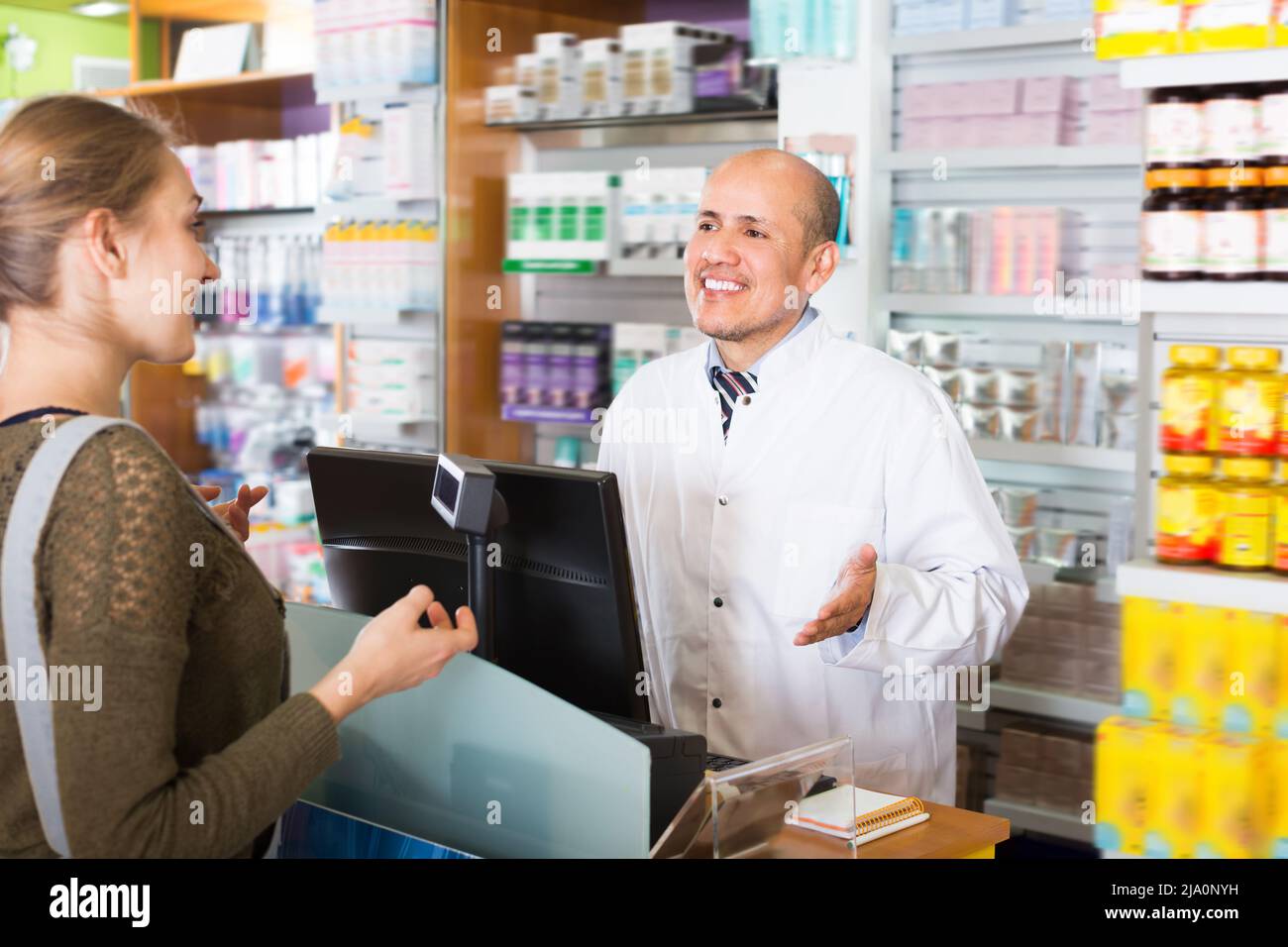 Pharmaceutist helping young girl in drugstore Stock Photo - Alamy