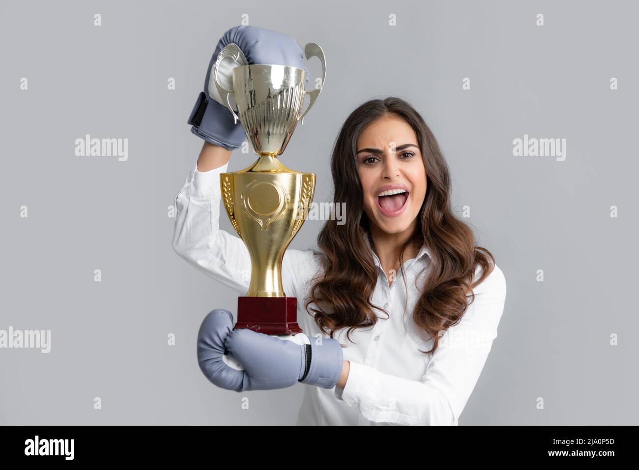 Woman in boxing gloves hold champion winner cup, trophy. Screaming ...