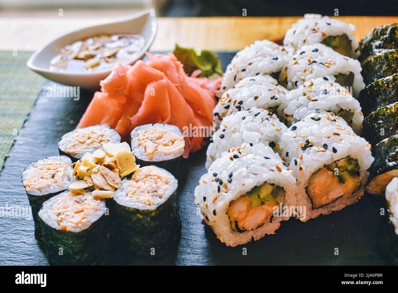 Sliced rolls of salmon sushi with ginger, wasabi and honey sauce Stock ...