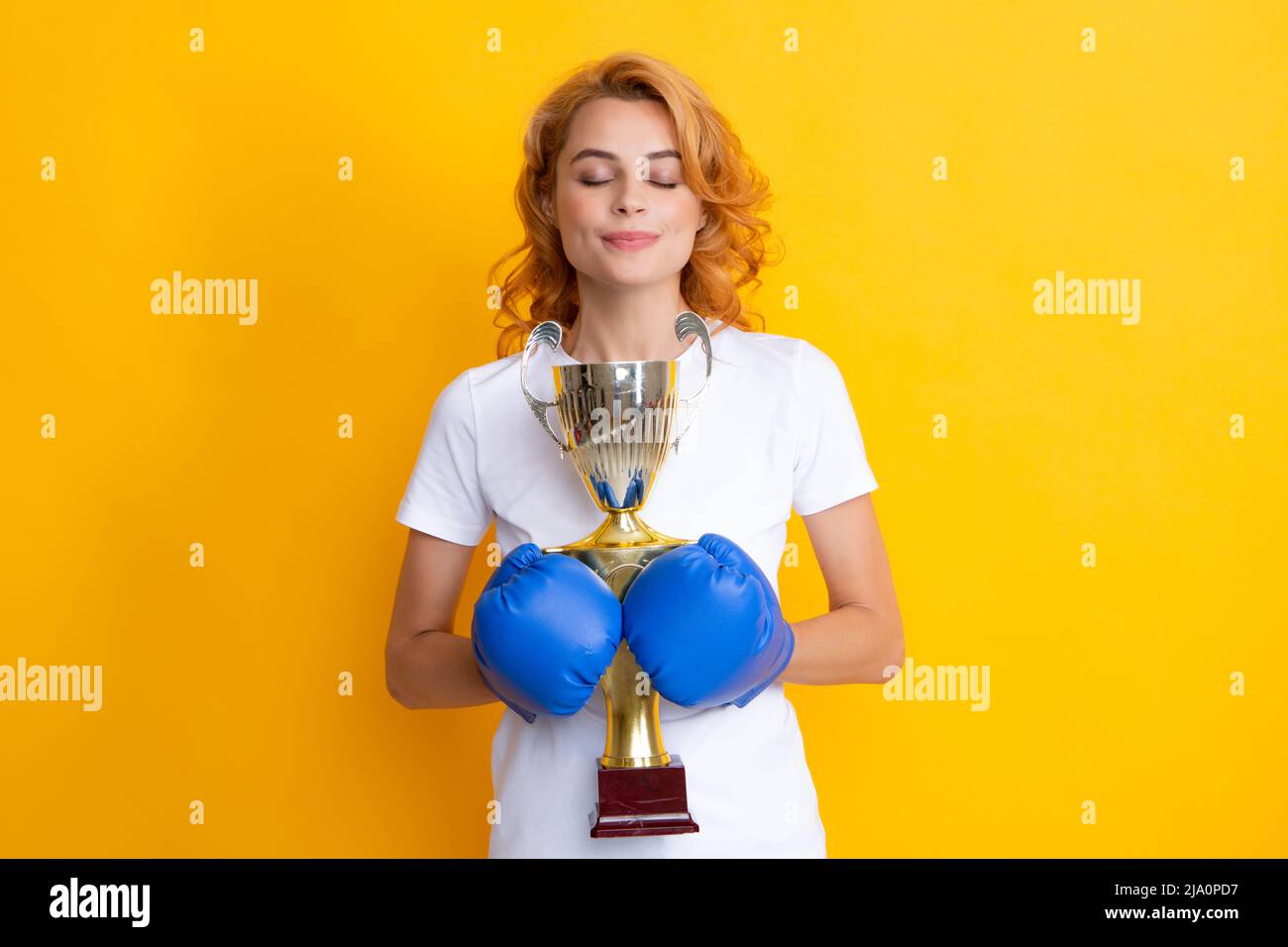 Woman in boxing gloves hold champion winner cup trophy. Cheerful woman ...