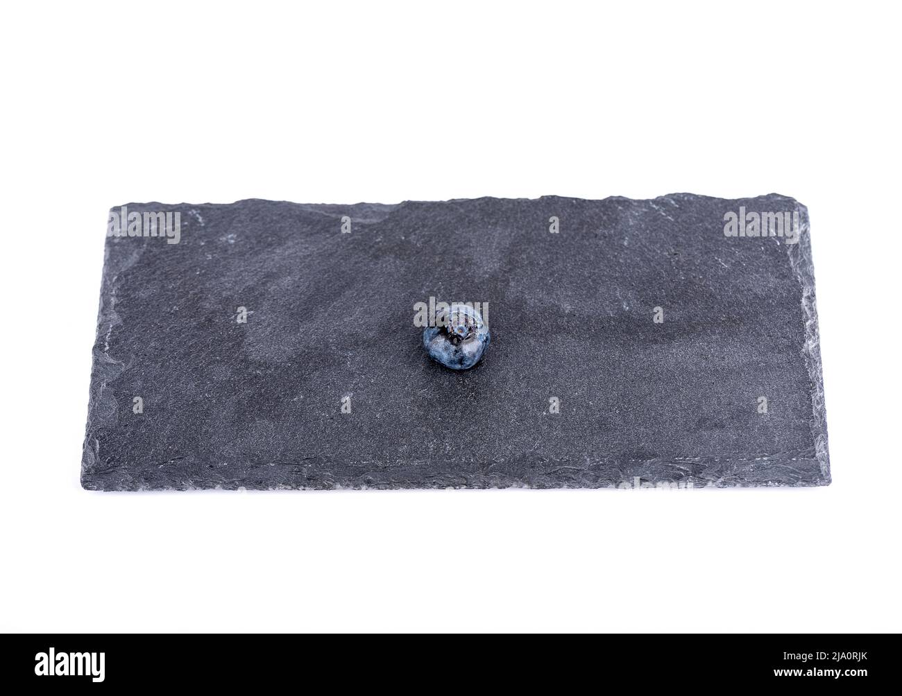 Blueberry on a stone board for serving over a white background. Copy ...