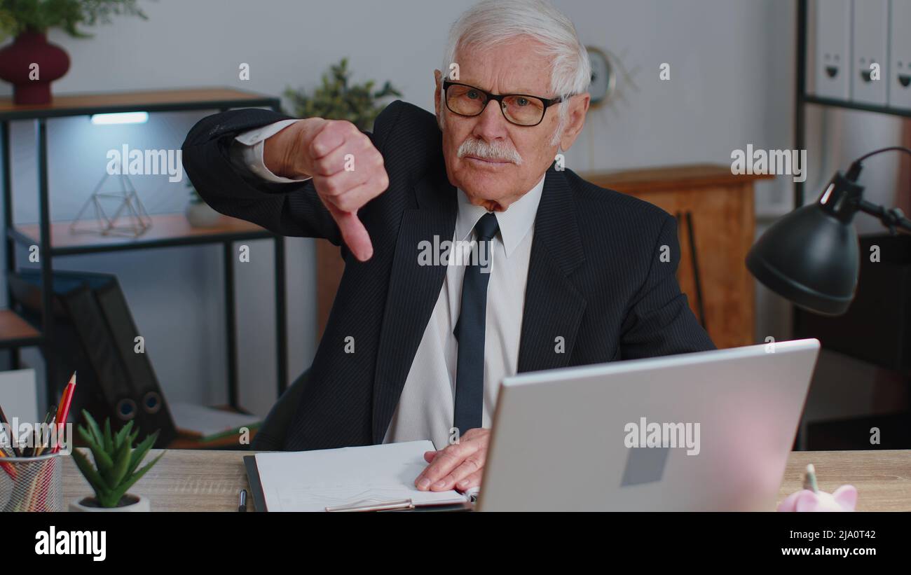 Upset senior business man showing thumbs down sign gesture, disapproval ...