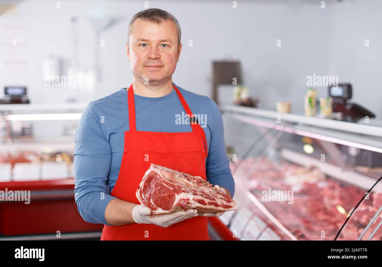 Portrait of man seller showing fresh meat Stock Photo - Alamy