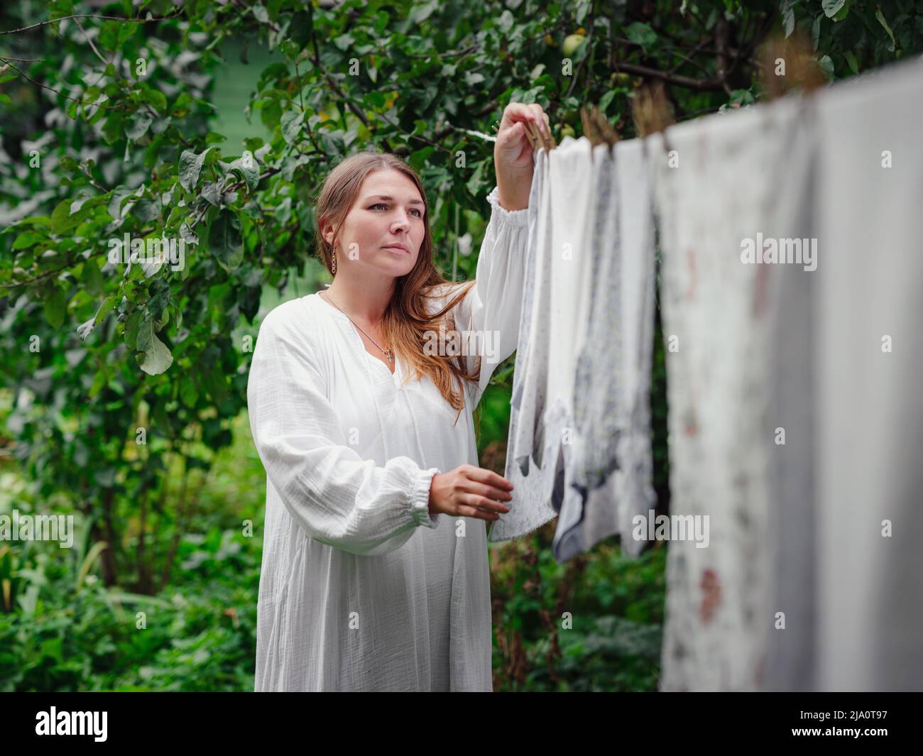 middle aged caucasian woman in white dress doing homework, hanging ...