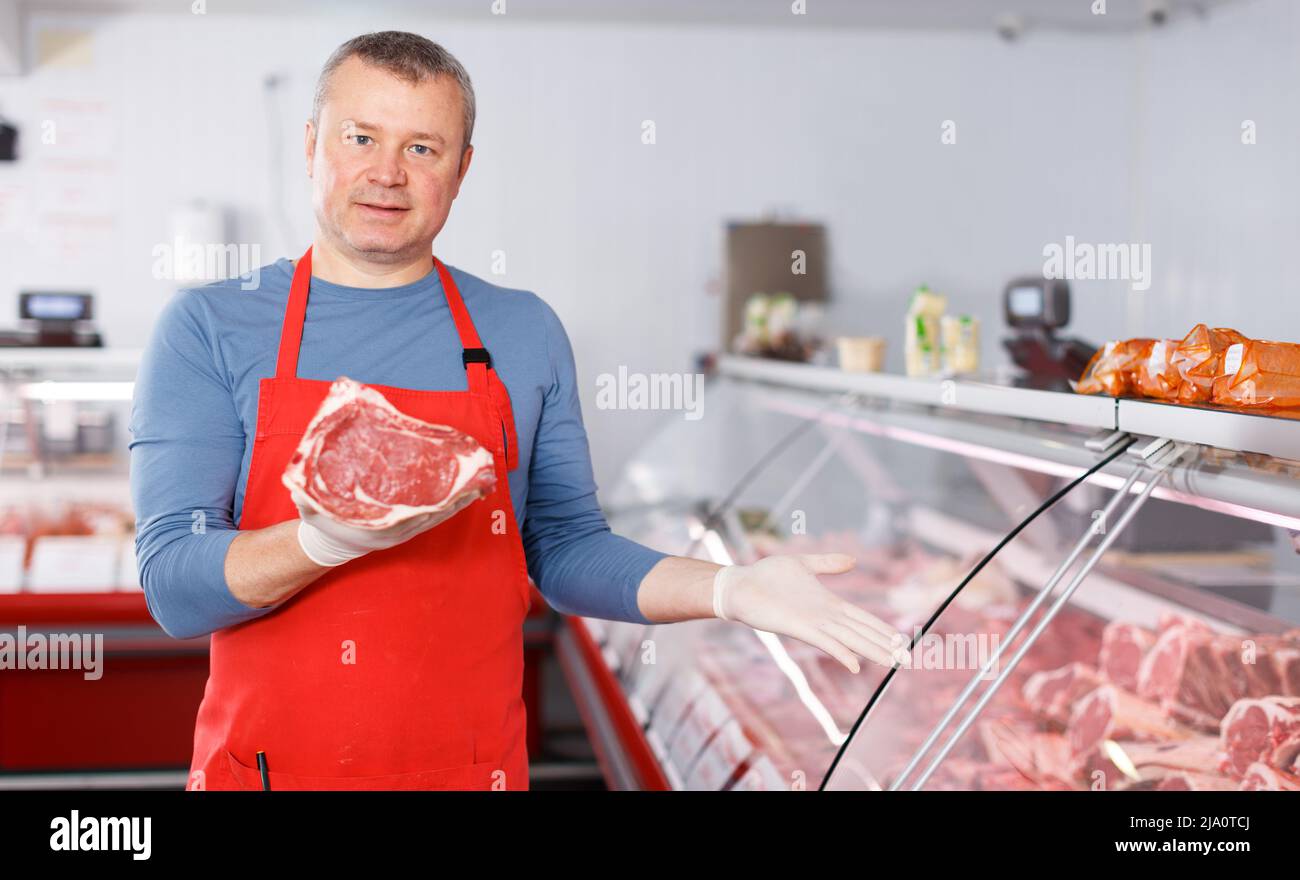 Portrait of man seller showing fresh meat Stock Photo - Alamy
