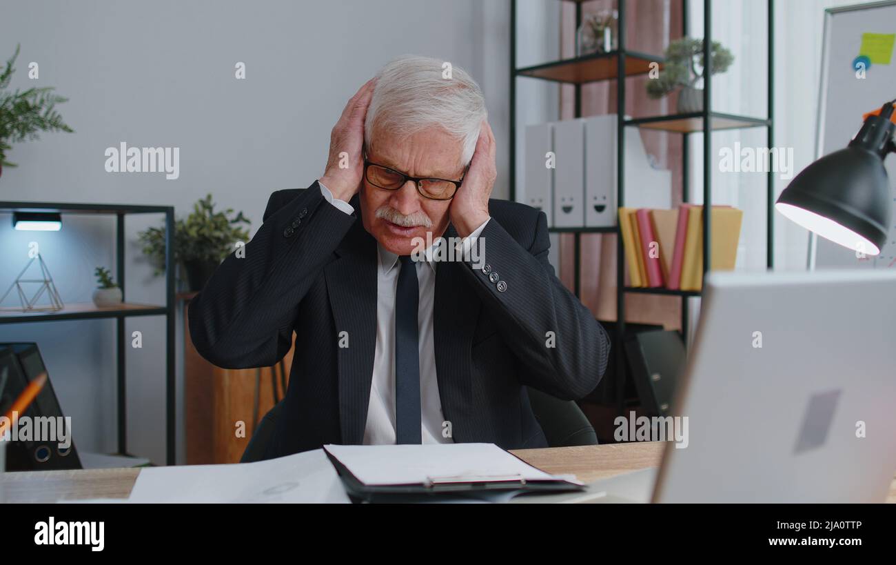 Senior business man analysing paperwork documents loses, bad fortune ...