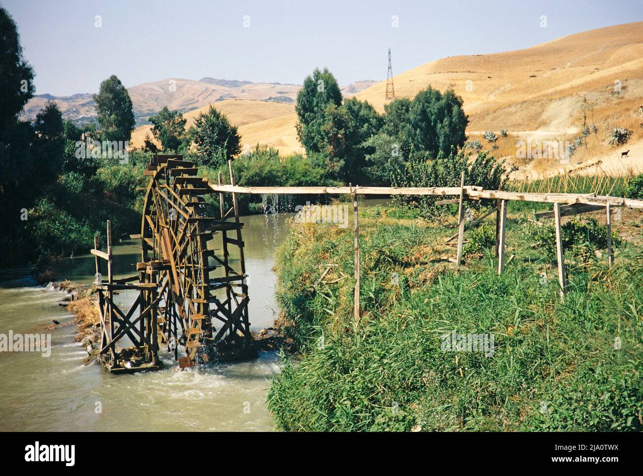 Water wheel supplying water to irrigation channel from river, west of ...