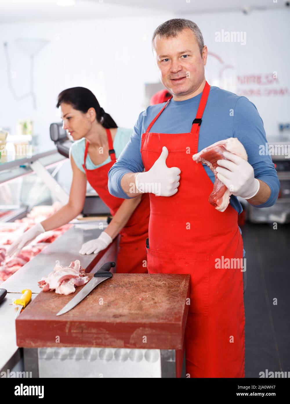 Happy female butcher cutting meat hi-res stock photography and images ...