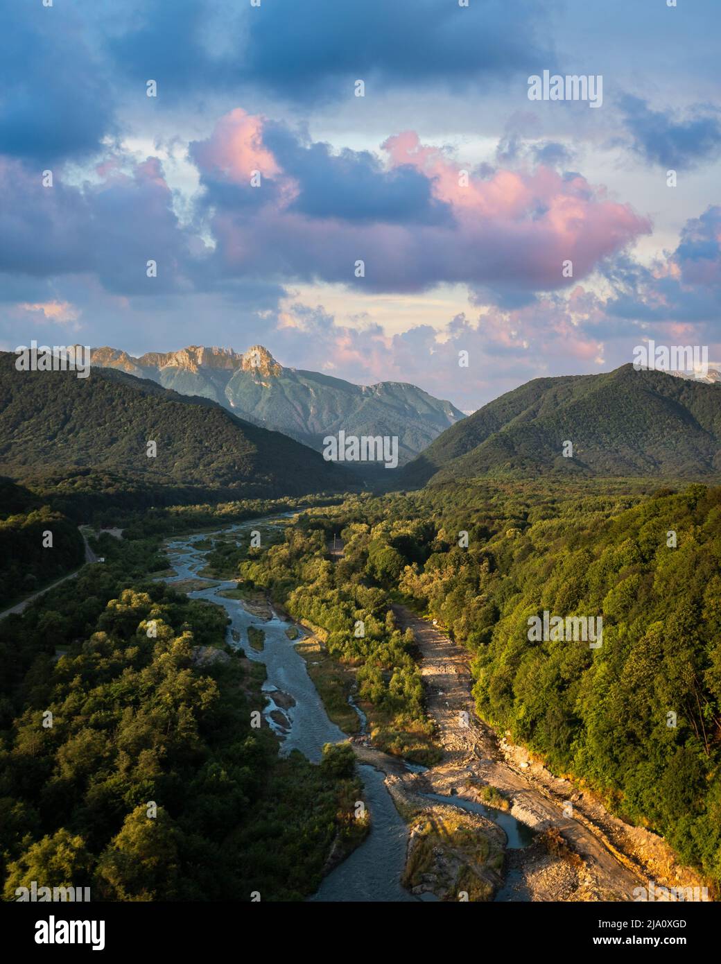 High angle aerial view of river and road running through forest and ...