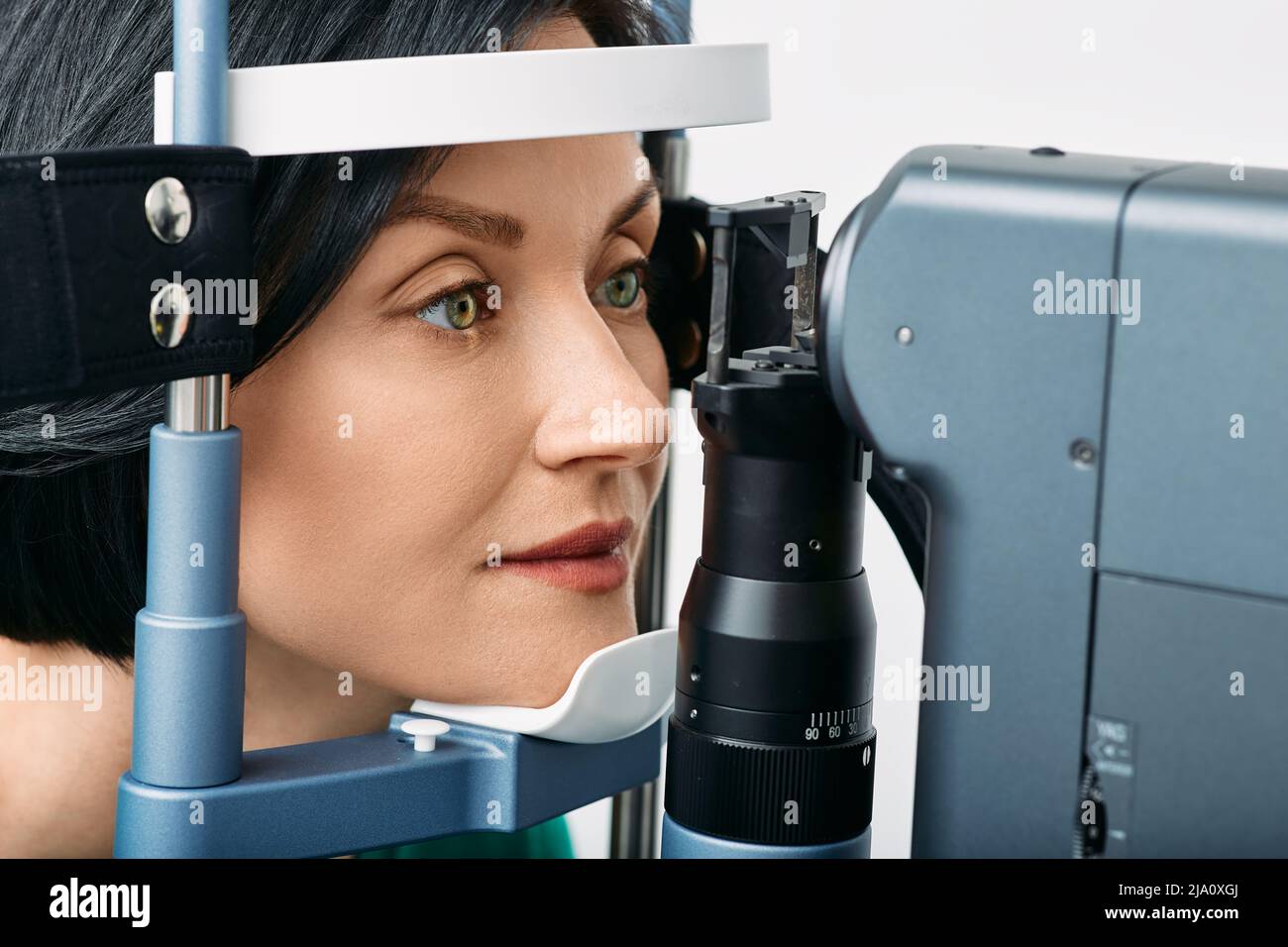 Woman getting vision test with binocular slit-lamp at ophthalmology ...