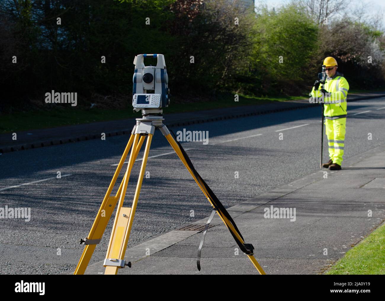 Site engineer doing road survey using modern robotic total station EDM ...