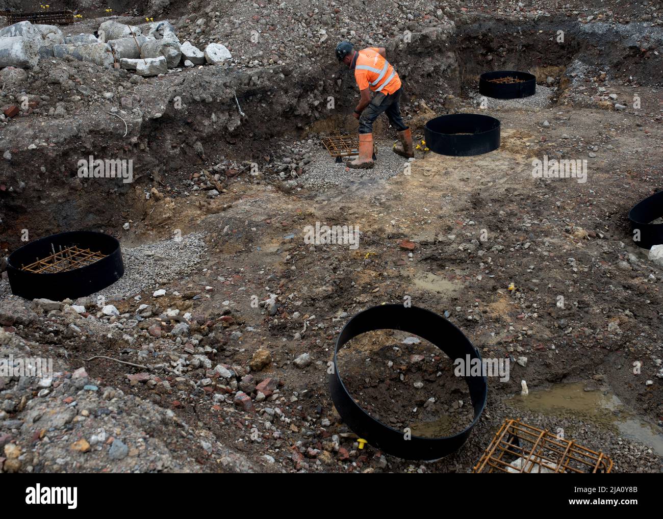 Construction worker installing reinforcement cages on top of piles to ...