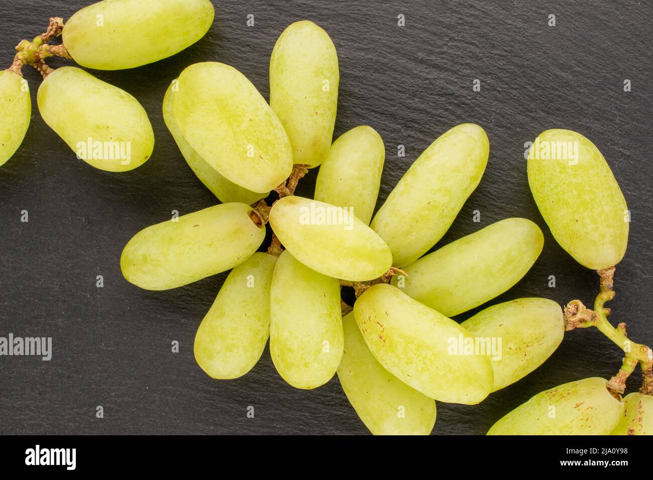One bunch of seedless white grapes on a slate stone, close-up, top view Stock Photo - Alamy