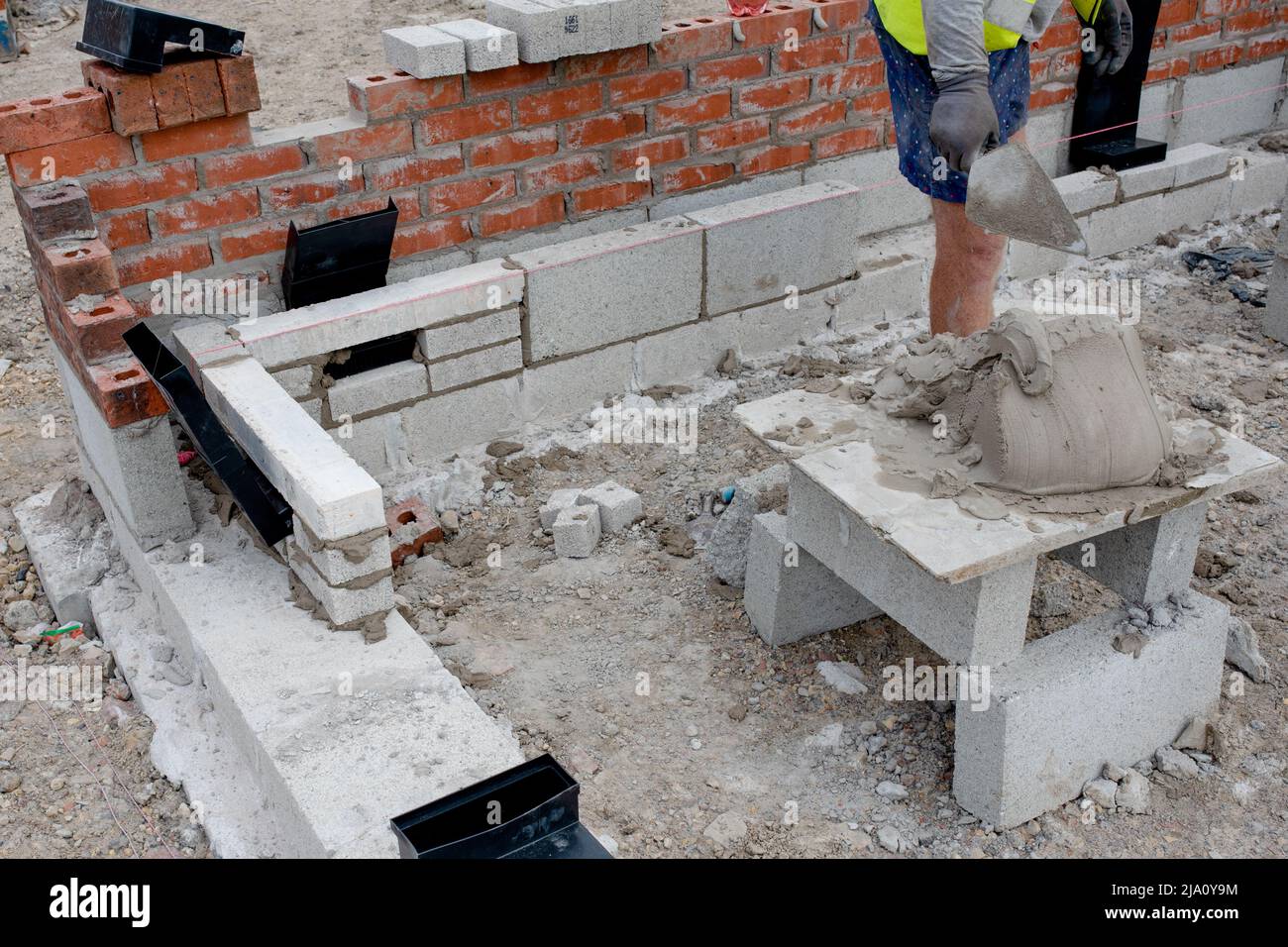 Bricklayer laying bricks on mortar on new residential house ...