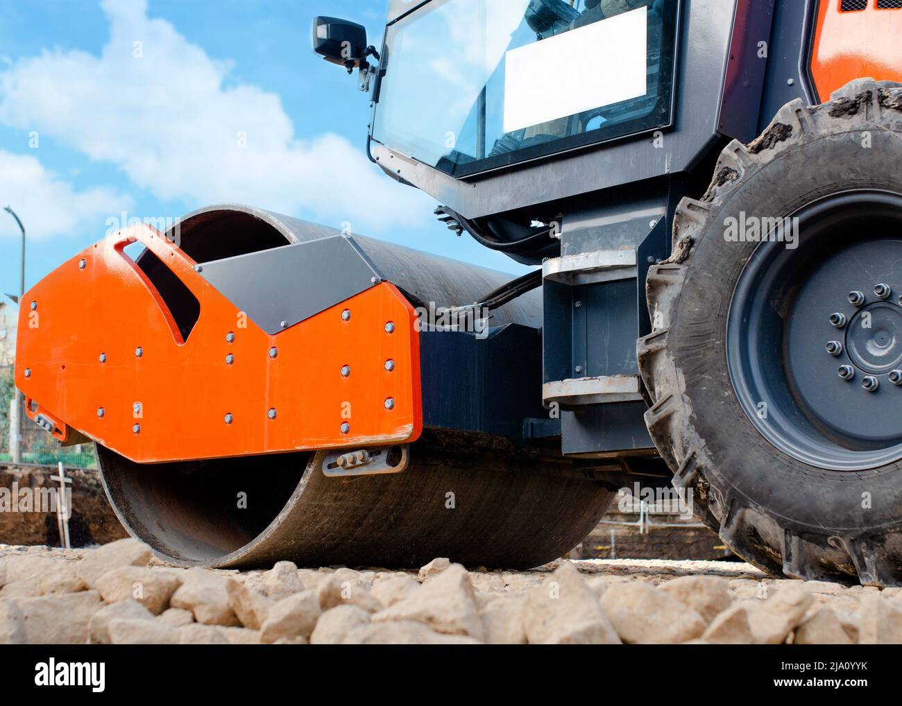 Heavy duty road vibrating roller compacting stone during new road ...