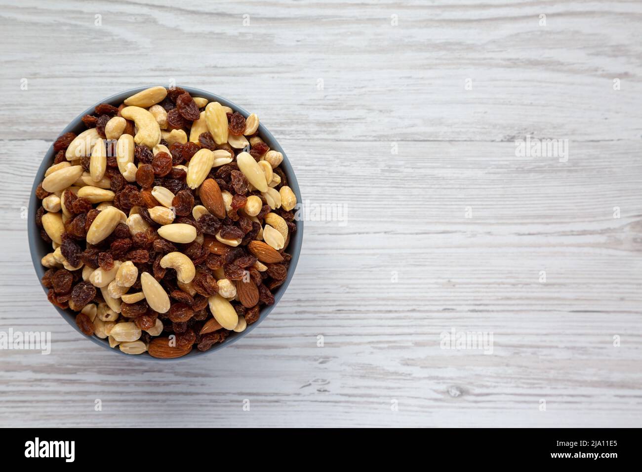 Raw Trail Mix with Nuts and Fruits in a Bowl on a white wooden ...