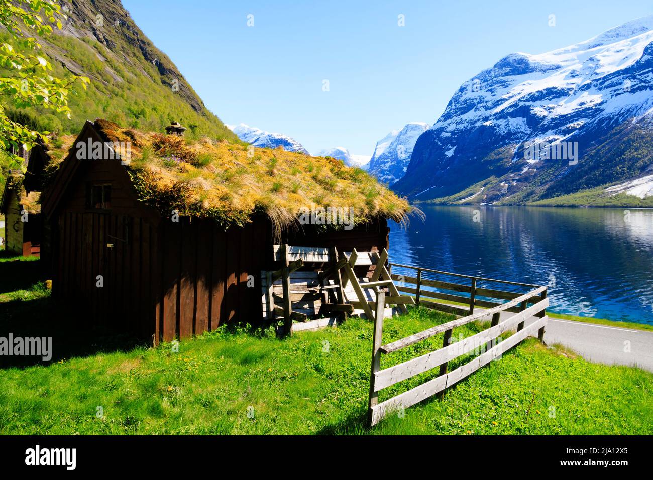 Traditional grass roofed wooden farm cabins on the shore of Lake ...