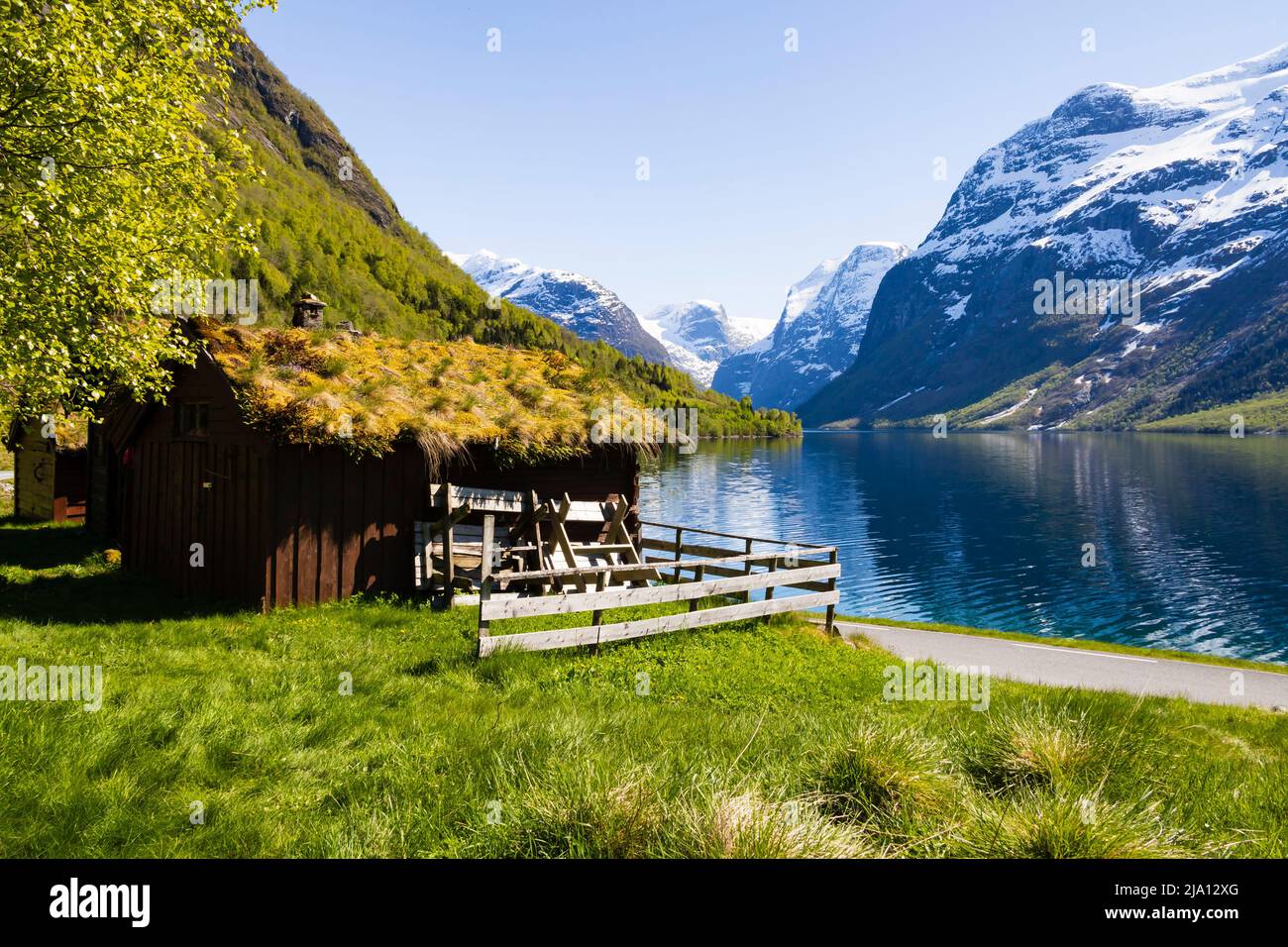 Traditional grass roofed wooden farm cabins on the shore of Lake ...