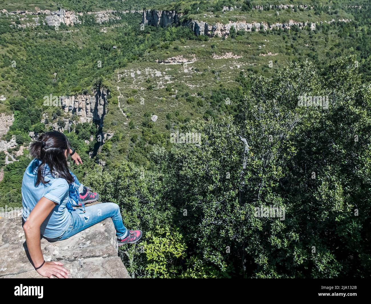 Young traveling woman sitting on the top of the mountain cliff with ...
