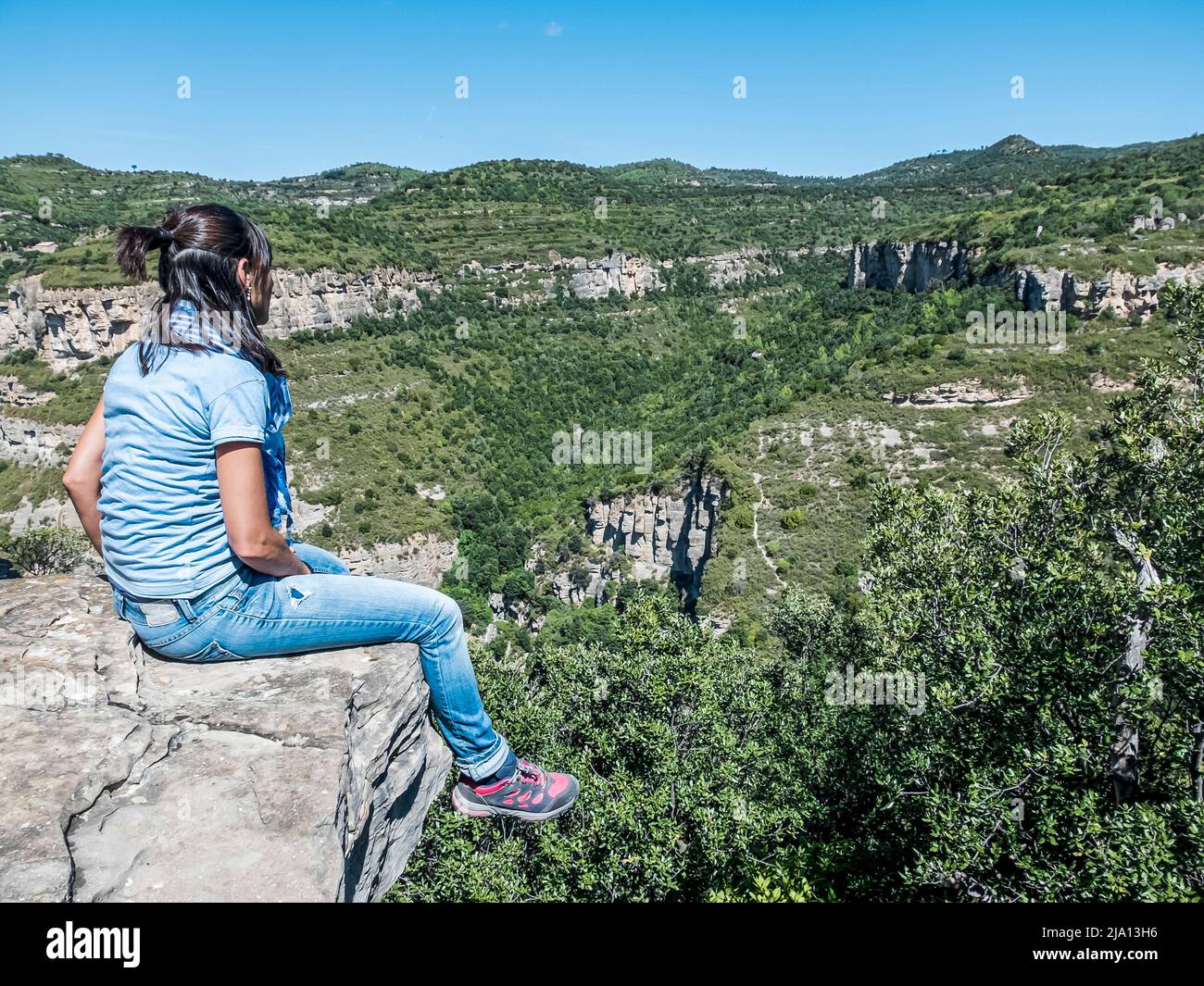 Young traveling woman sitting on the top of the mountain cliff with ...