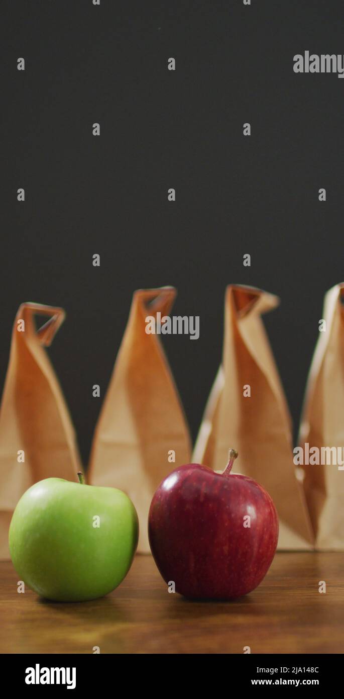 Vertical image of red and green apple with row of packed lunches in ...