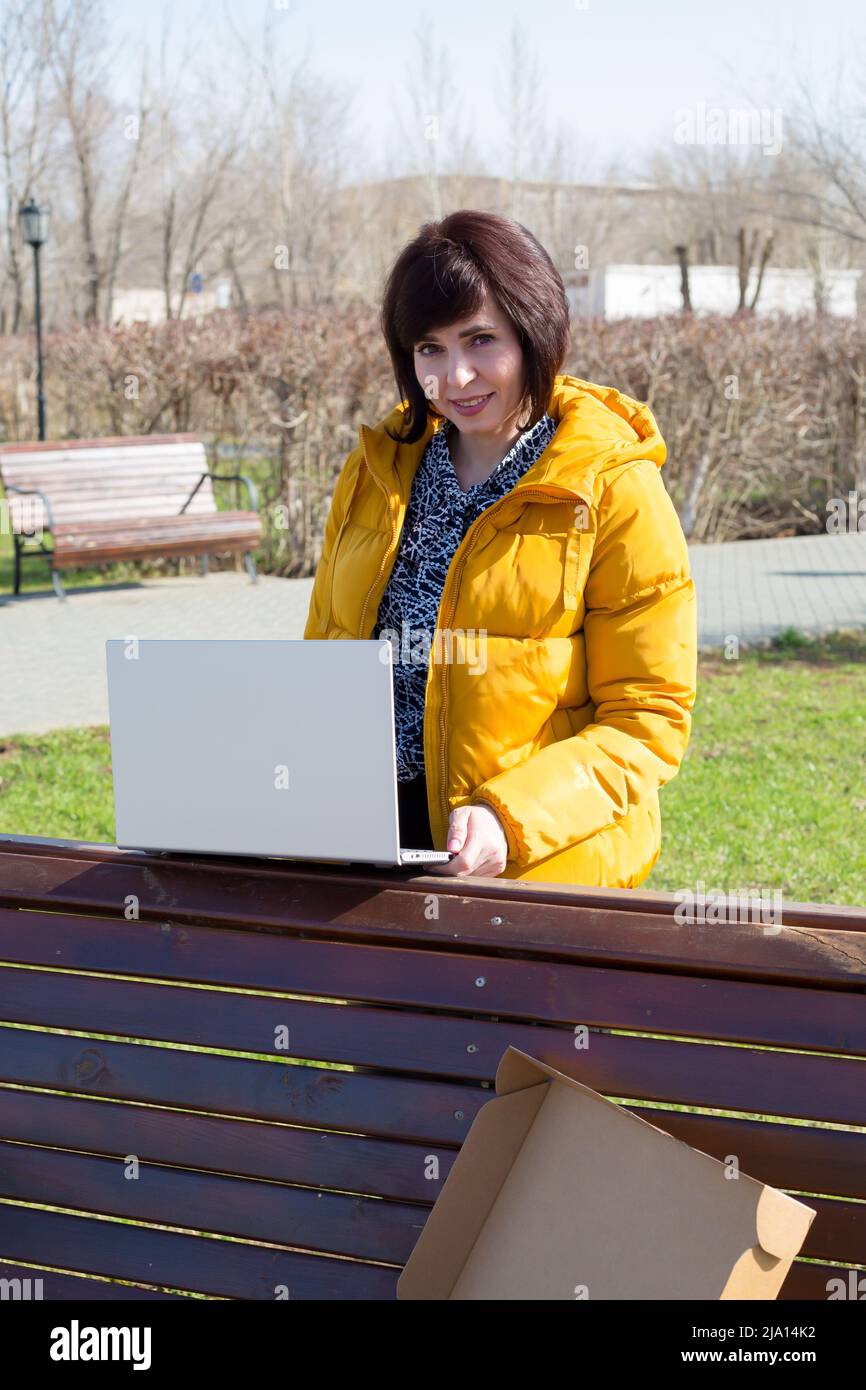 A brunette woman yellow warm jacket couldn't stand unpacking a new ...