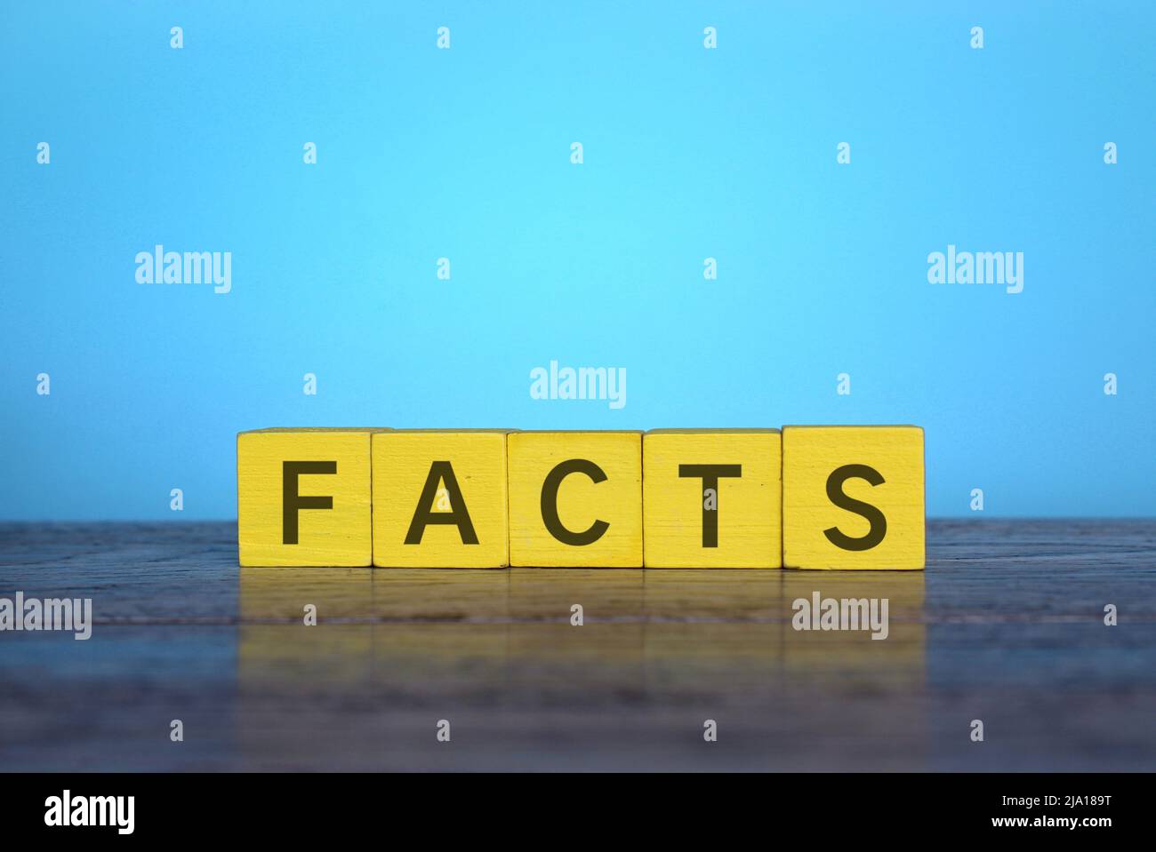 Wooden cubes on table with text FACTS. Blue background Stock Photo - Alamy