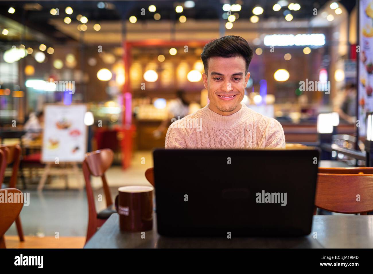 Cheerful young guy using laptop hi-res stock photography and images - Alamy