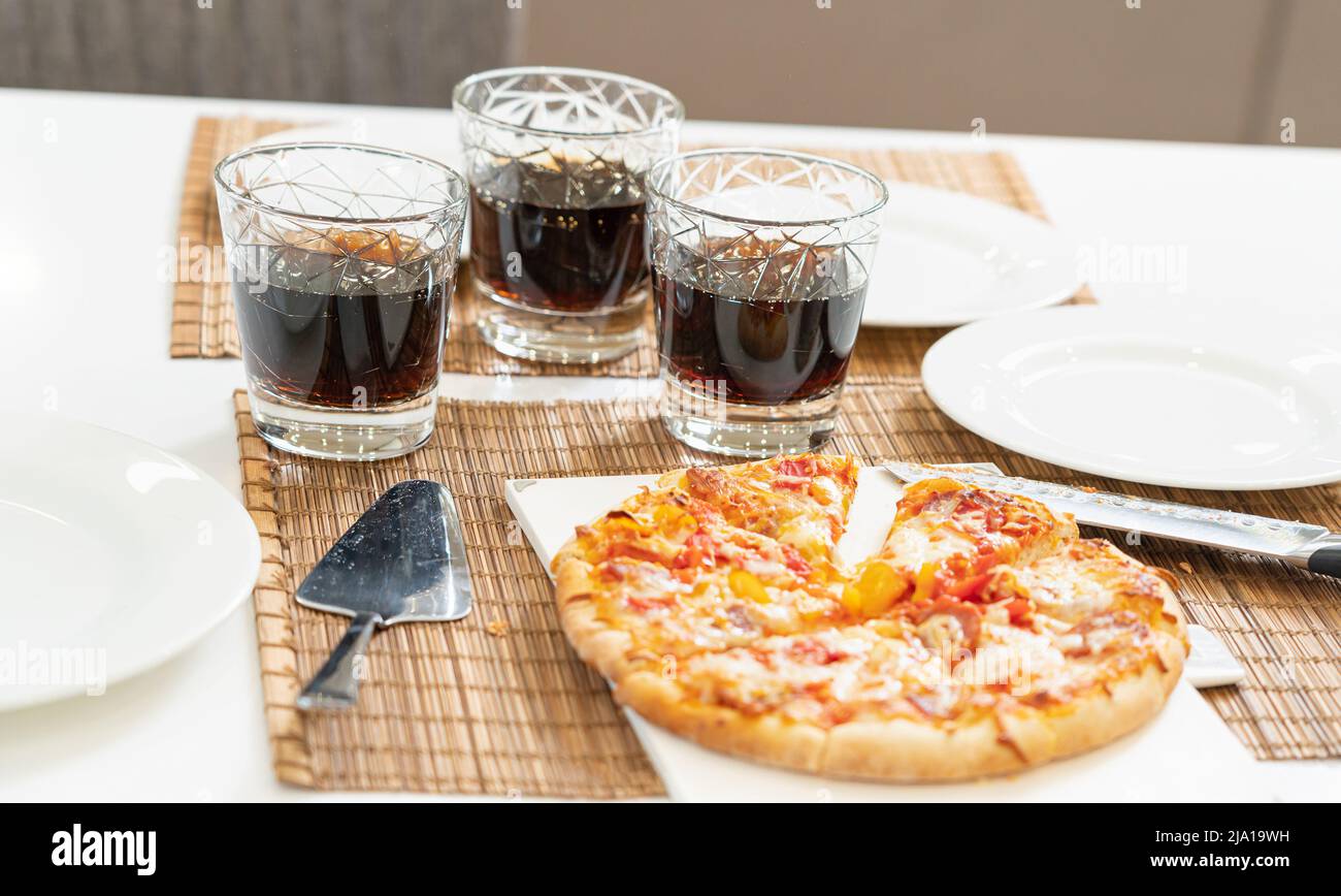 homemade pizza and glasses with coca-cola on the table evening dinner ...