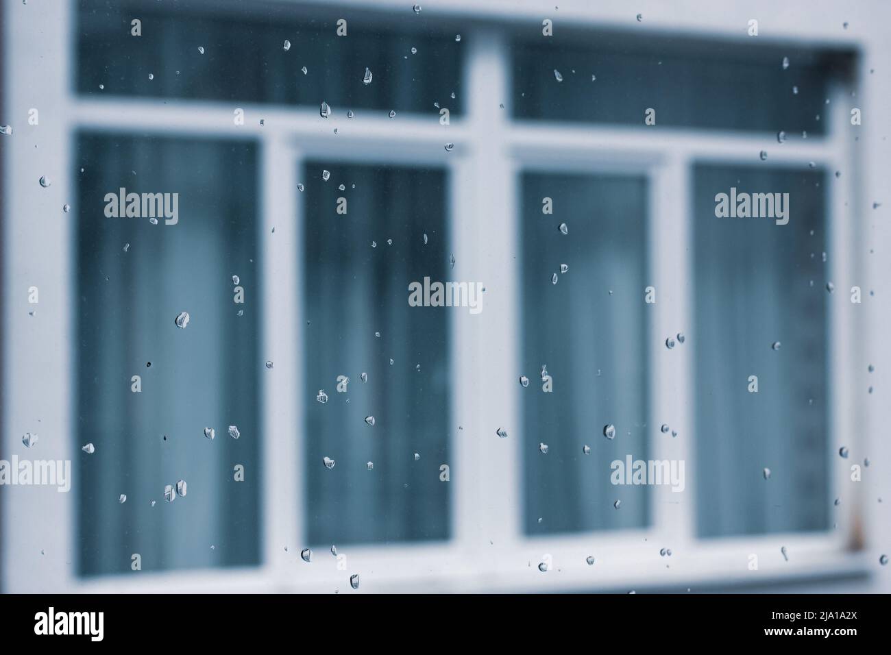Rain outside the window. The surface of a glass is dotted with small ...